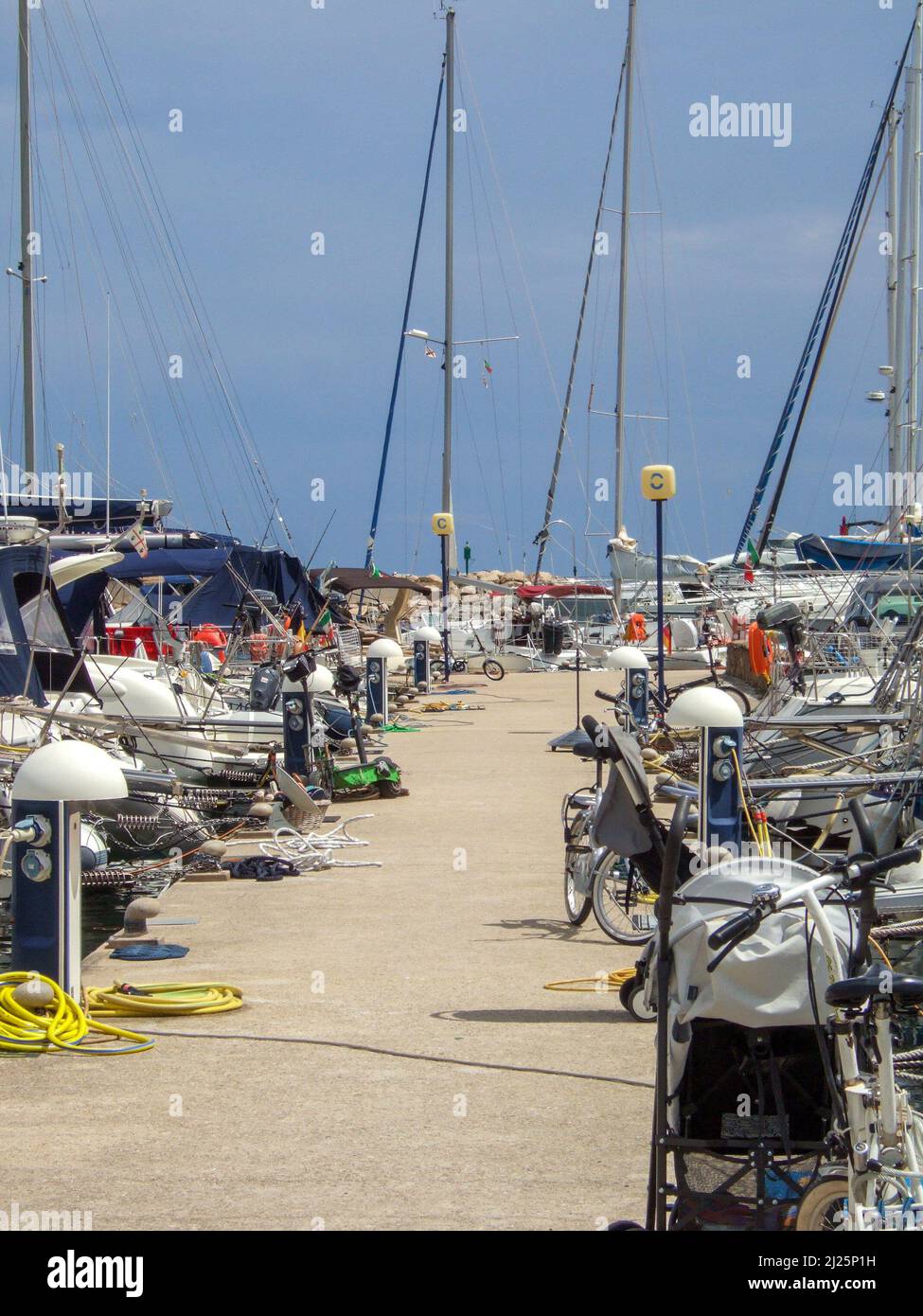 A jetty at the yacht and sailing harbor in Budoni with many moored ...
