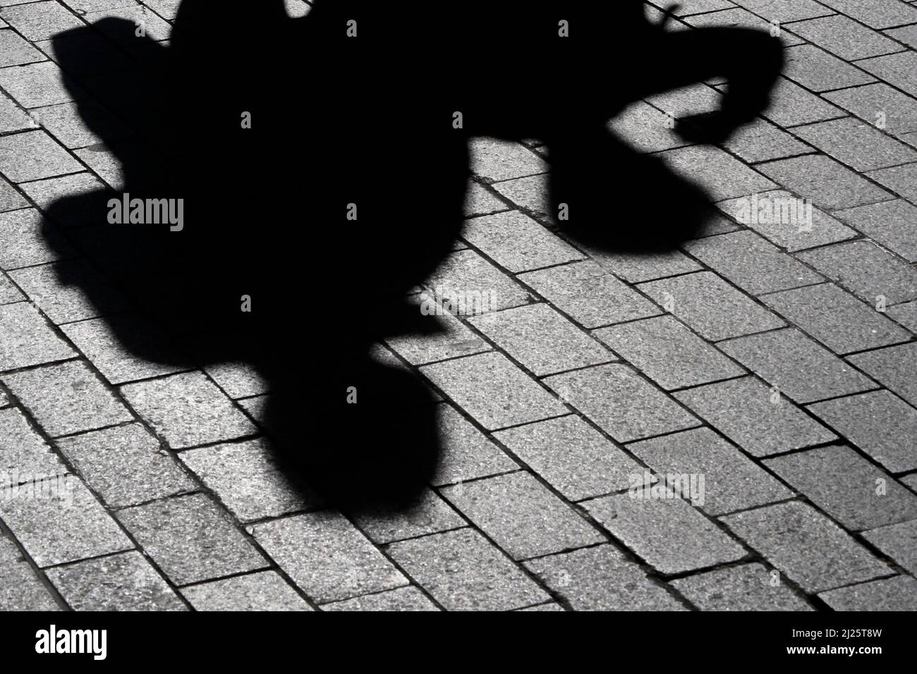 Shadows and silhouettes of people on the cobblestone pavement Stock ...