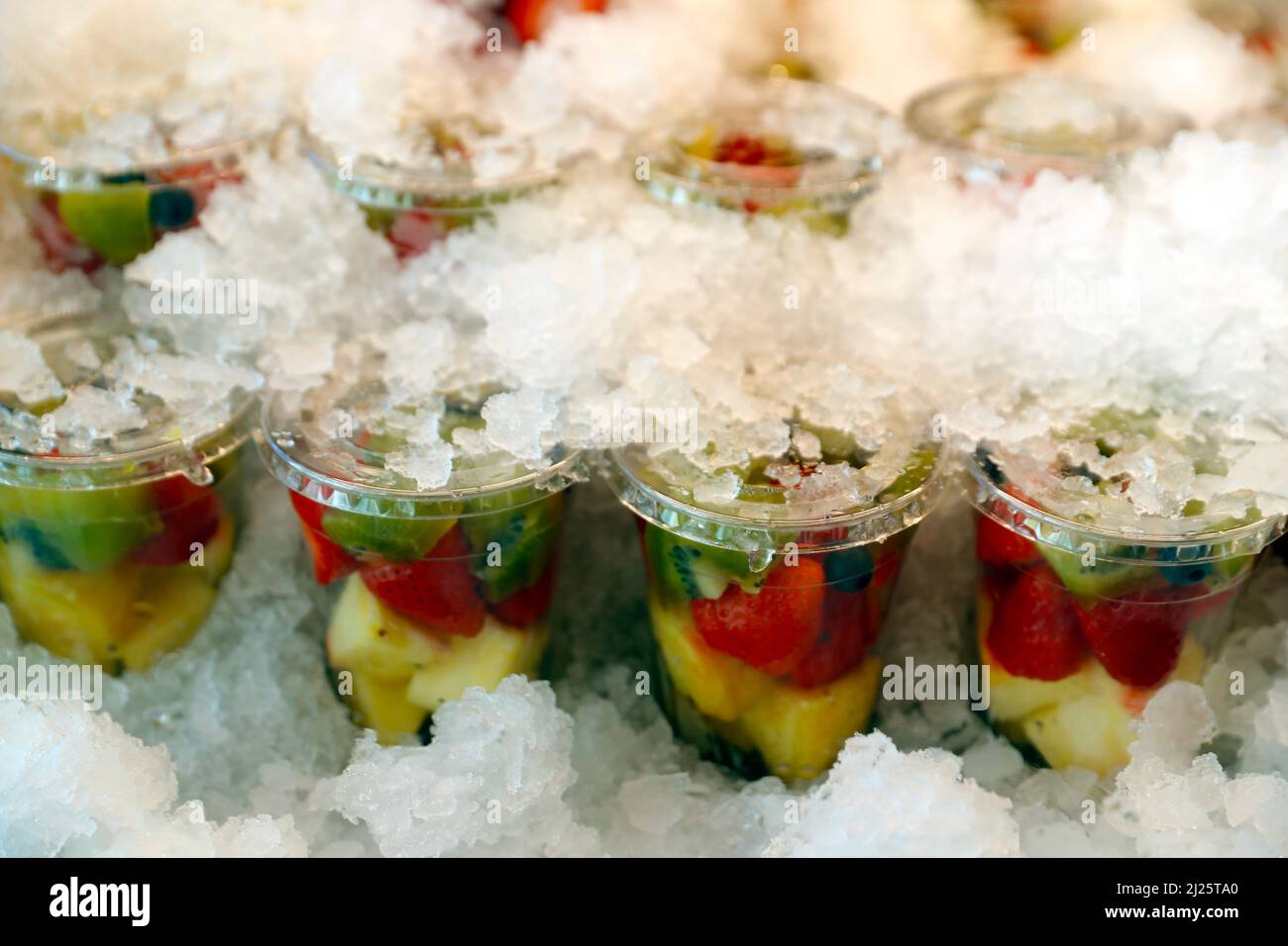 Cup of fresh fruits with ice for sale at market Stock Photo - Alamy