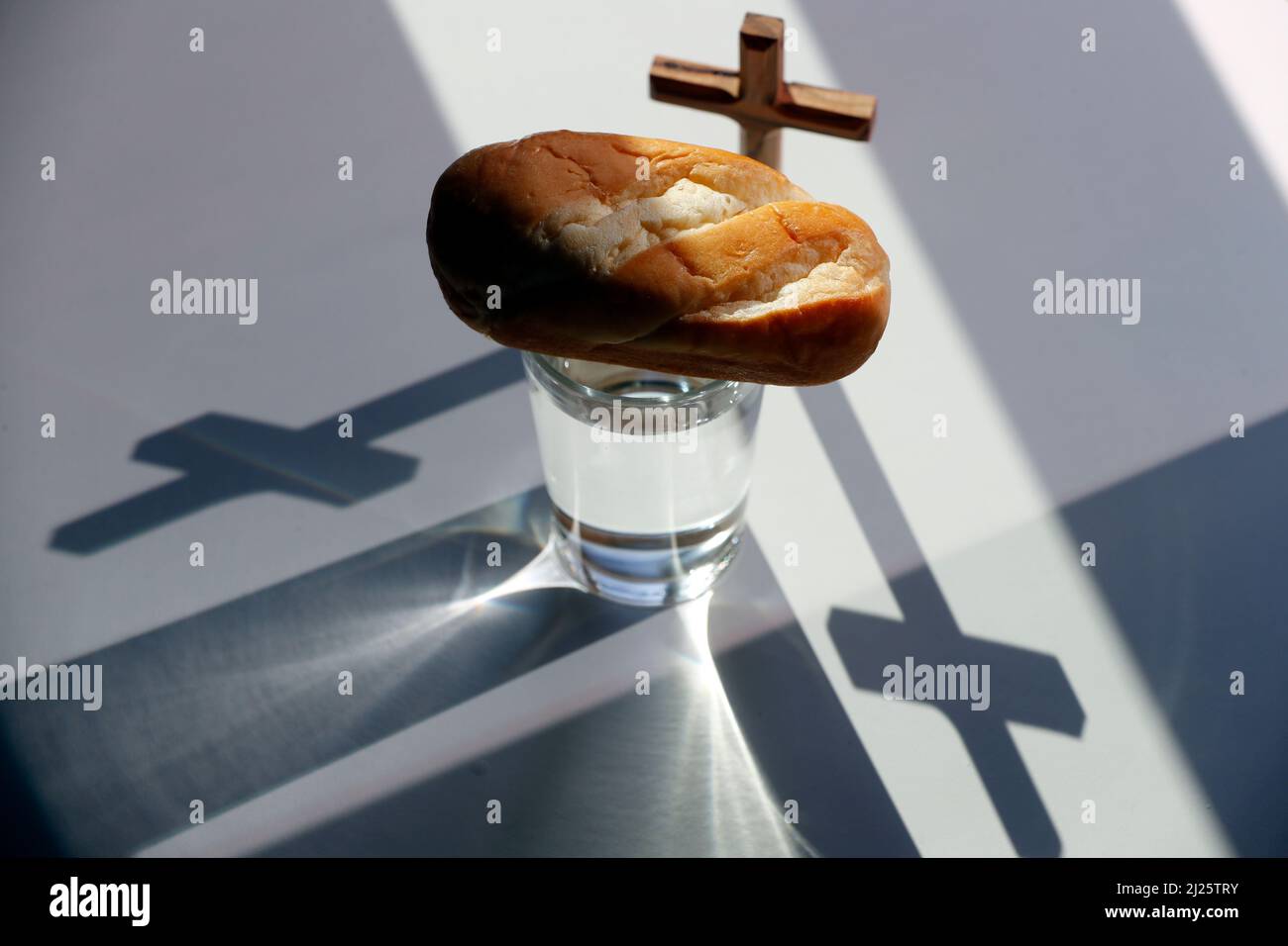 Bread and water lent before easter with a wooden cross Stock Photo - Alamy