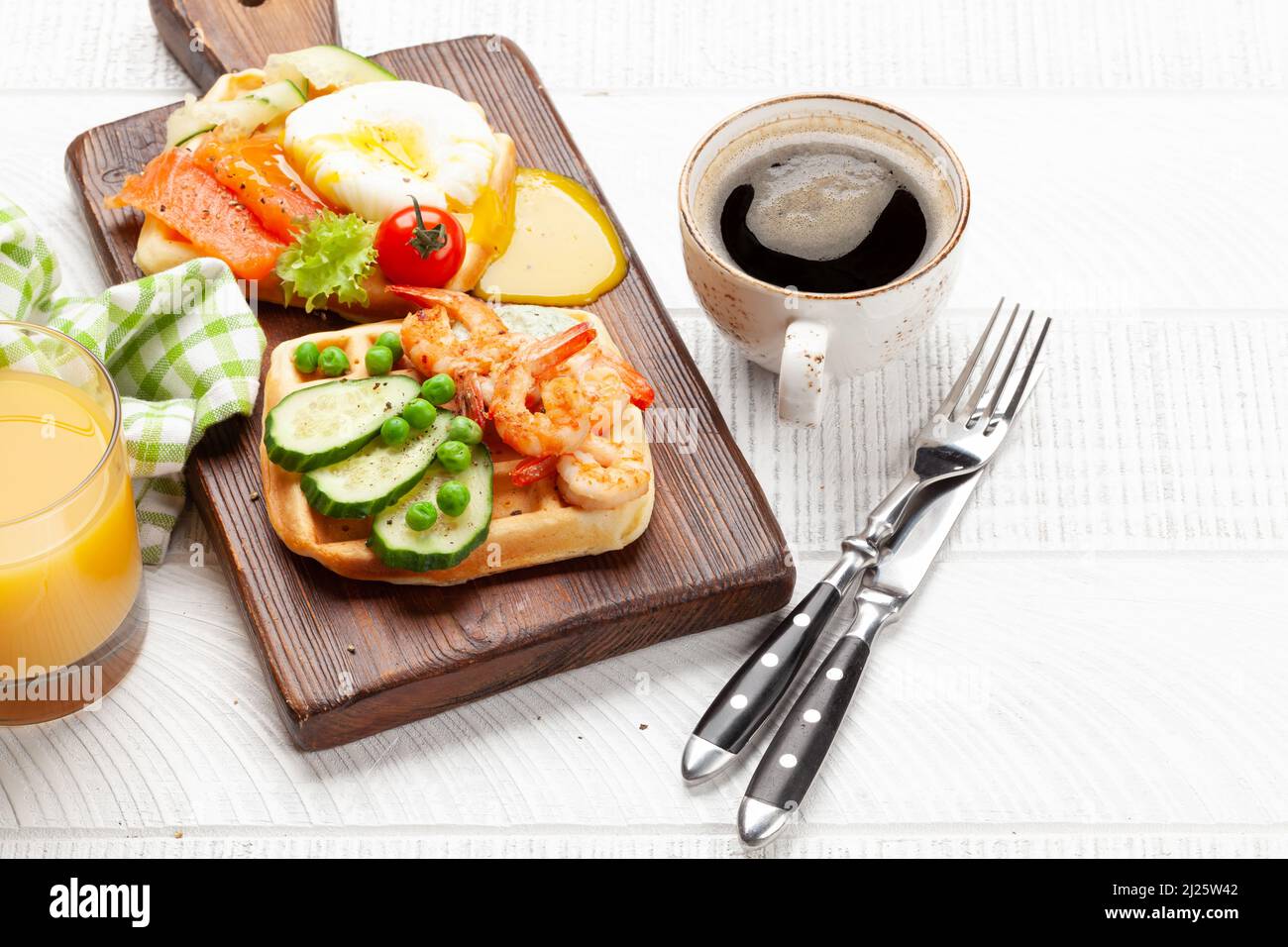 Breakfast waffles with fried eggs, salmon, bacon, cucumber and prawns ...