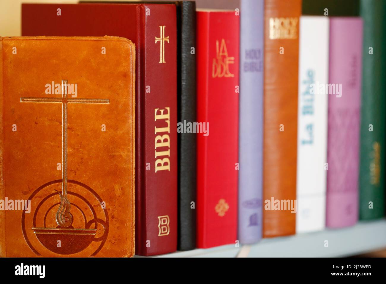 Christian bibles of different versions on a bookshelf. Religious symbol ...