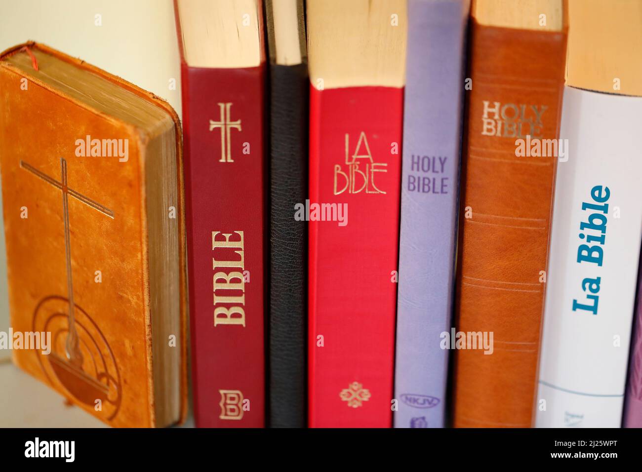 Christian bibles of different versions on a bookshelf. Religious symbol ...