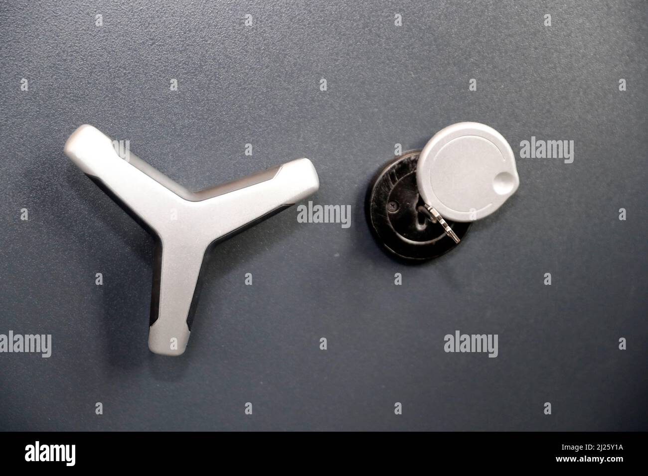 Silver Key in the keyhole of a gray safe Stock Photo - Alamy