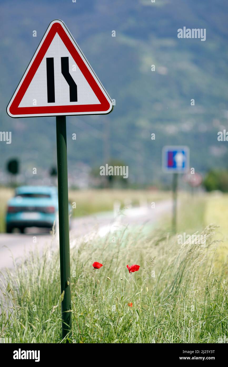 Triangular road narrowing sign on country side road Stock Photo - Alamy