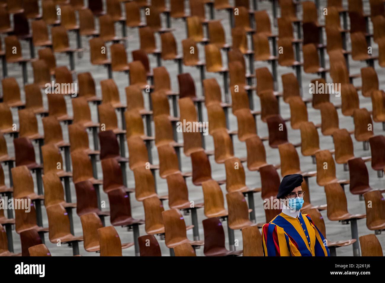 A Swiss guard wearing a face mask stands in an almost empty Paul VI ...