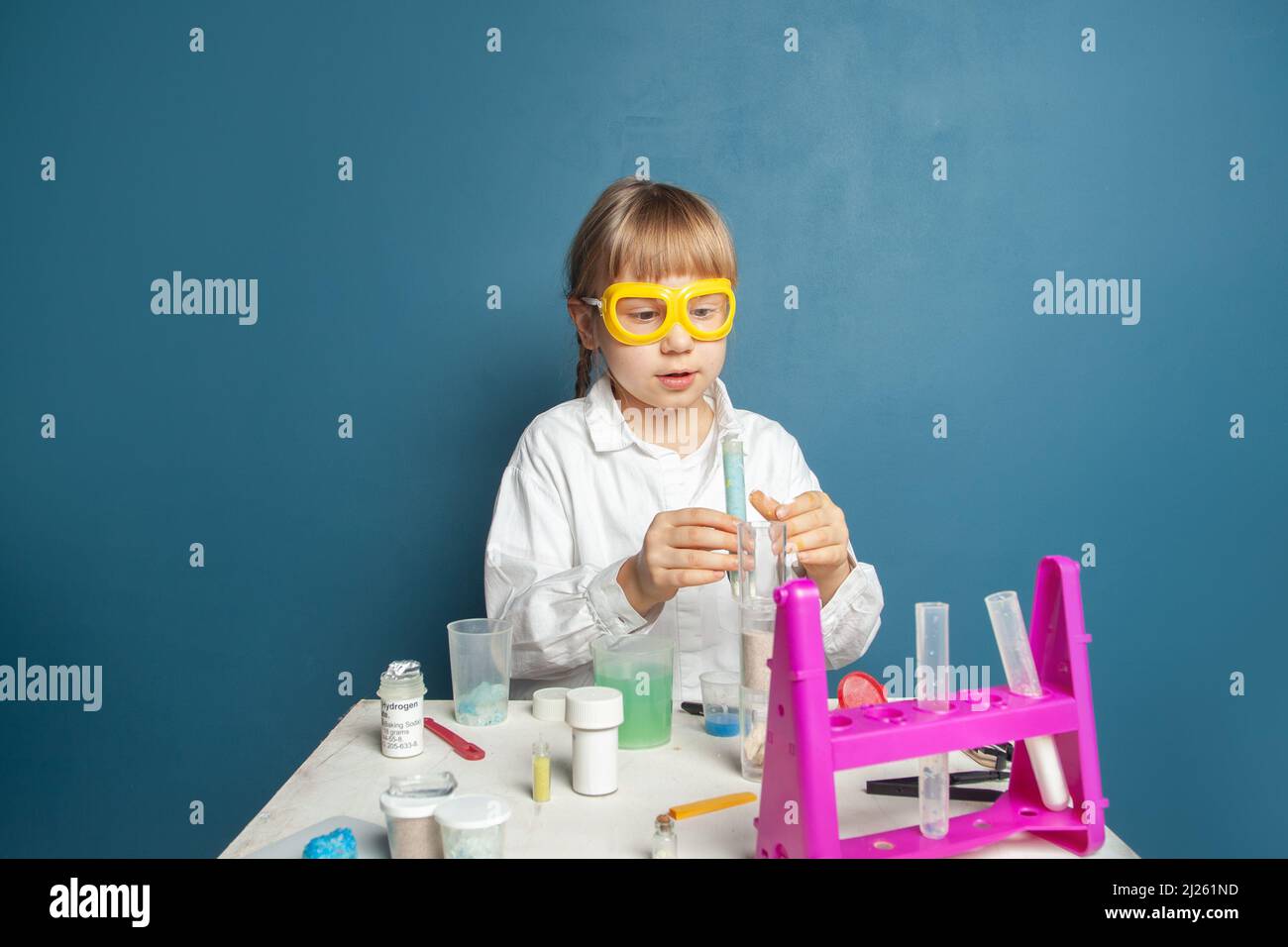 Smart kid student in scientist uniform and glasses studying science ...
