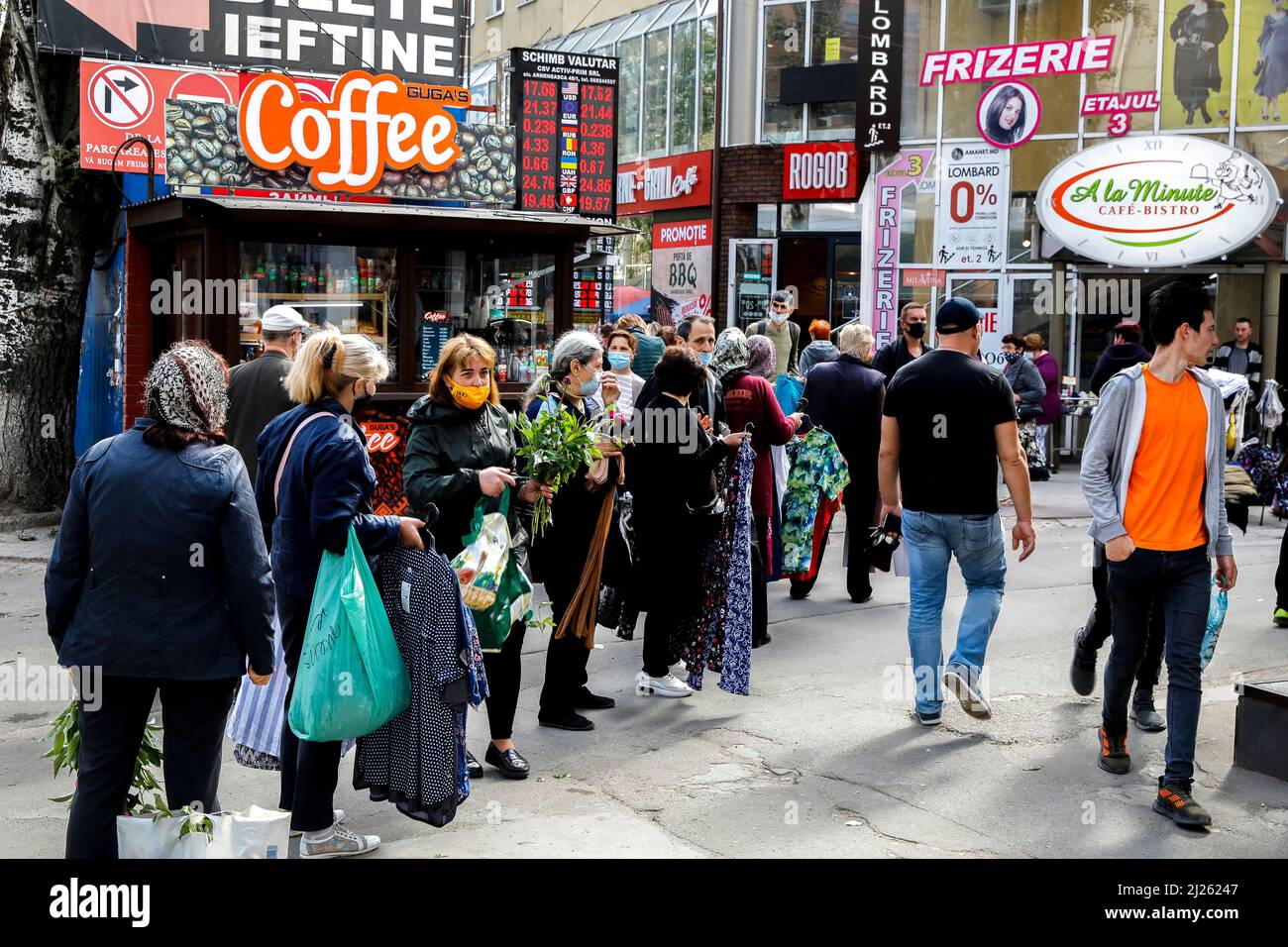 Women selling goods on a street outside the central market in Chisinau ...