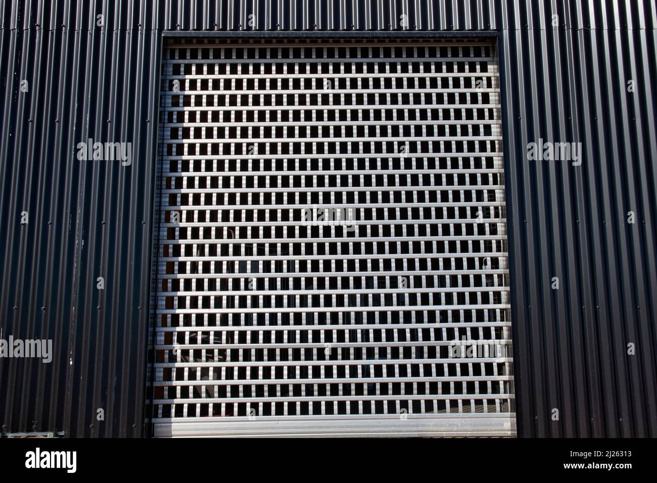 industrial storehouse with closed gray metal roller shutter Stock Photo ...