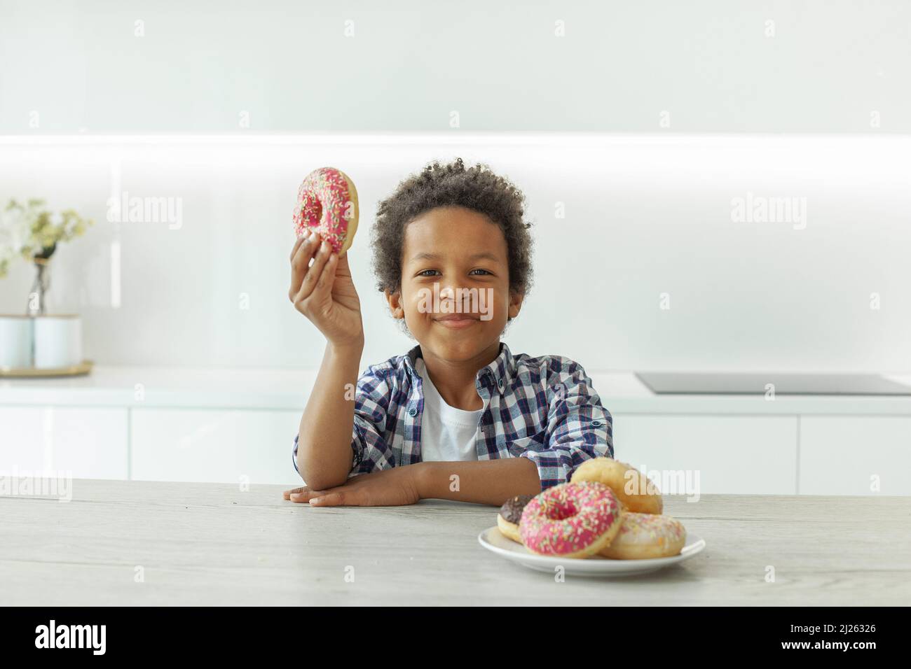 Little boy eating donut Stock Photo - Alamy