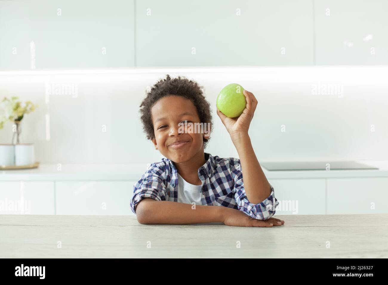 Positive little boy with fresh green apple looking at camera Stock ...