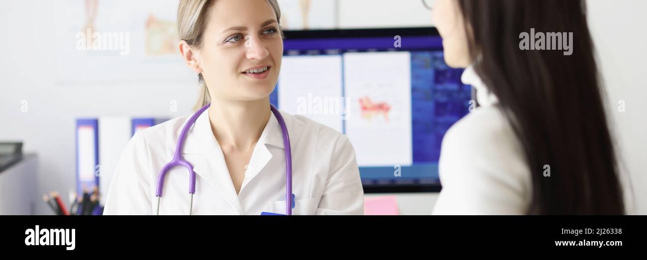 Portrait of smiling physician looking at woman patient with happiness ...