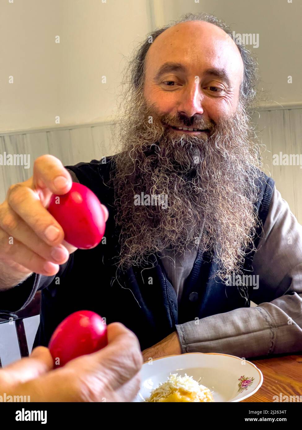 Abbot performing an egg ritual during lunch in Rudi orthodox monastery ...