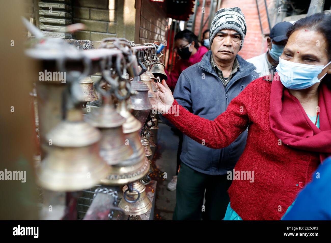 Hand of a nepali woman ringing a sacred bell in a Kathmandu temple ...