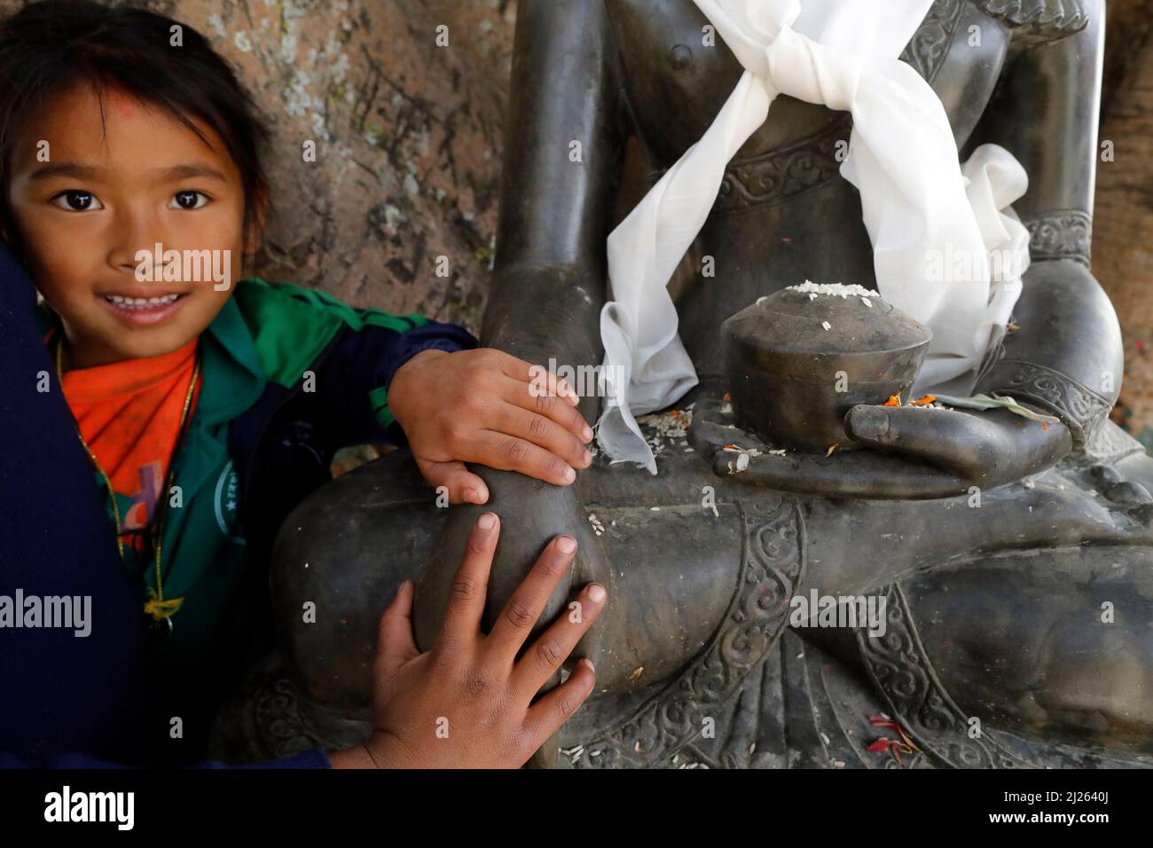 Buddhist shrine in the street. Child with Buddha statue Stock Photo - Alamy