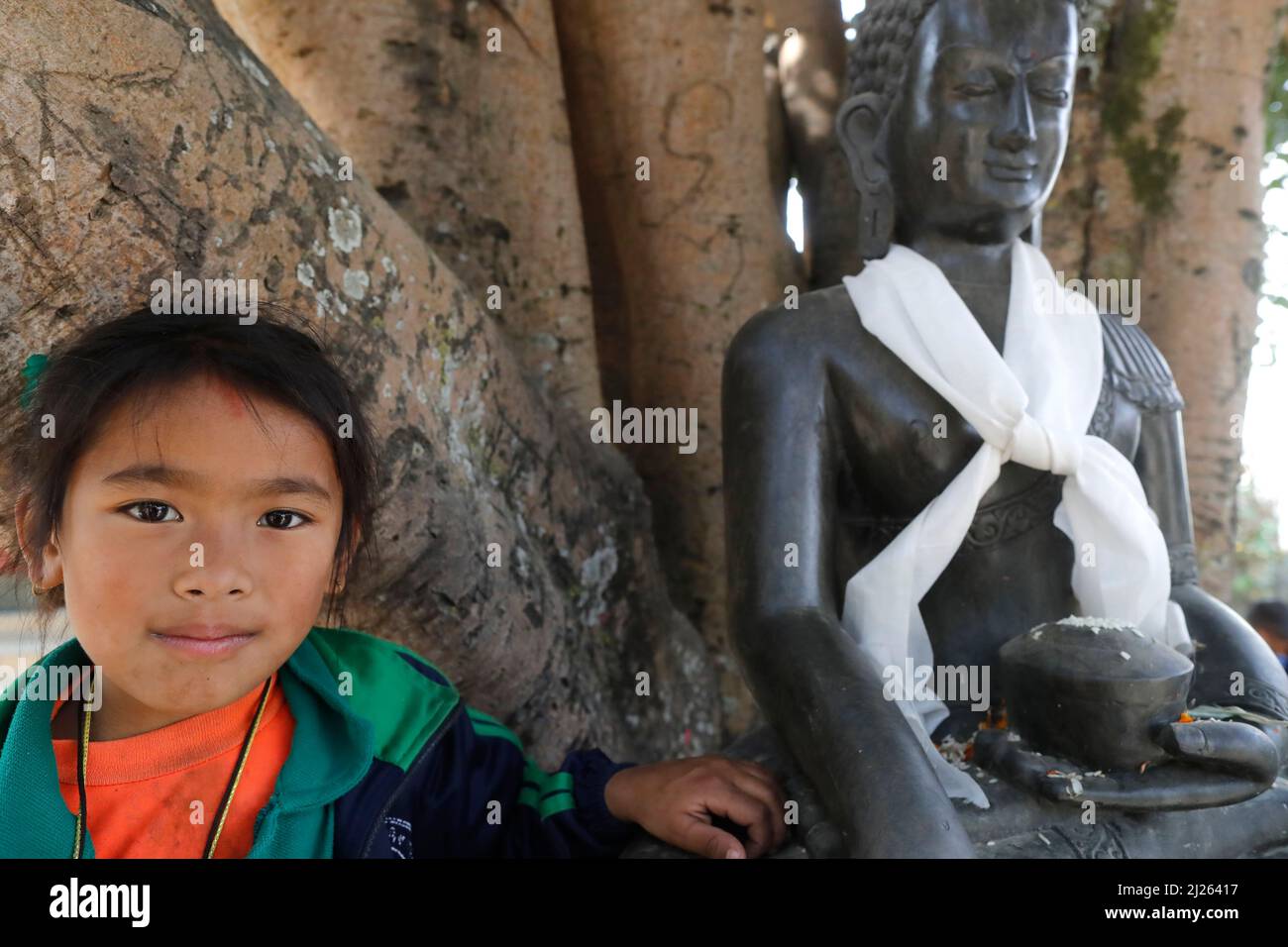 Buddhist shrine in the street. Child with Buddha statue Stock Photo - Alamy