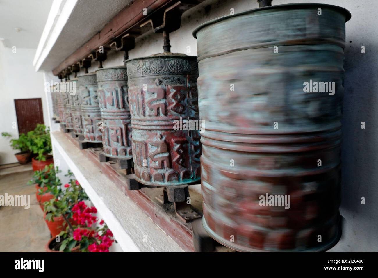 Pema Osel Ling Monastery. Rolling metal prayer wheels circling. A ...