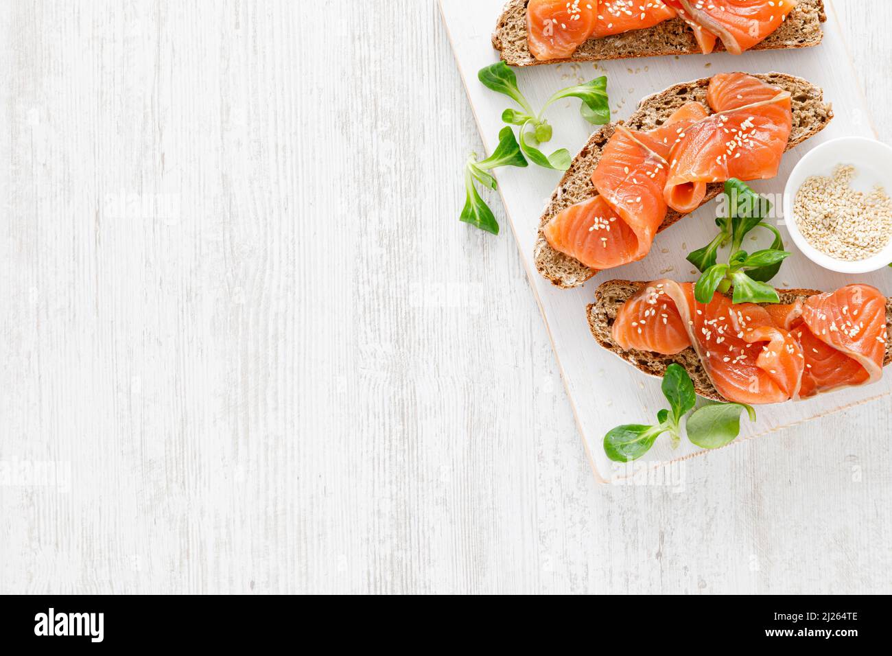 Whole grain rye bread open sandwiches with salted salmon on a white ...