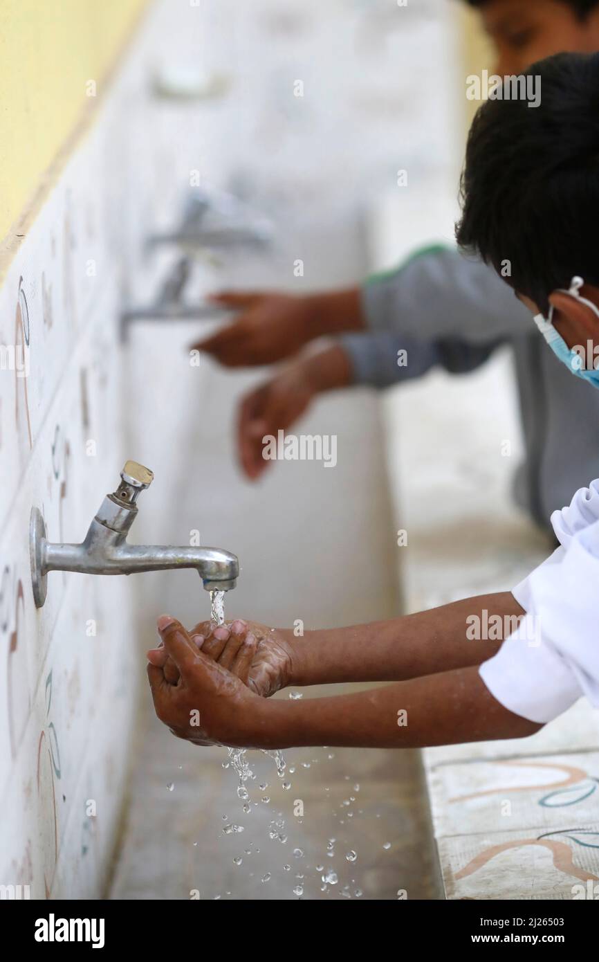 Primary school. Children school wash their hands with soap in the sink ...