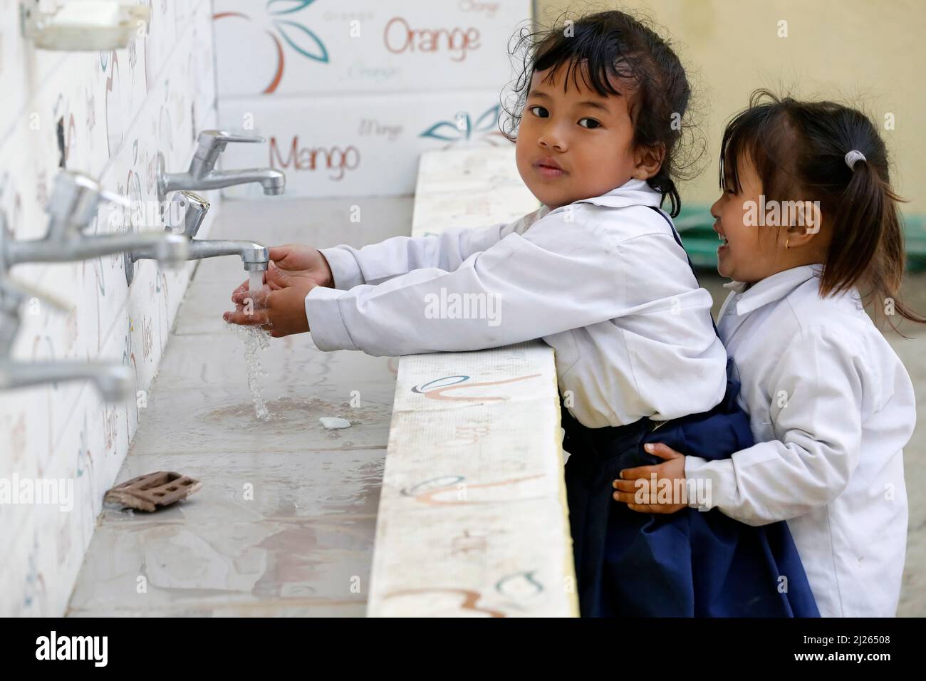 Primary school. Children school wash their hands with soap in the sink ...