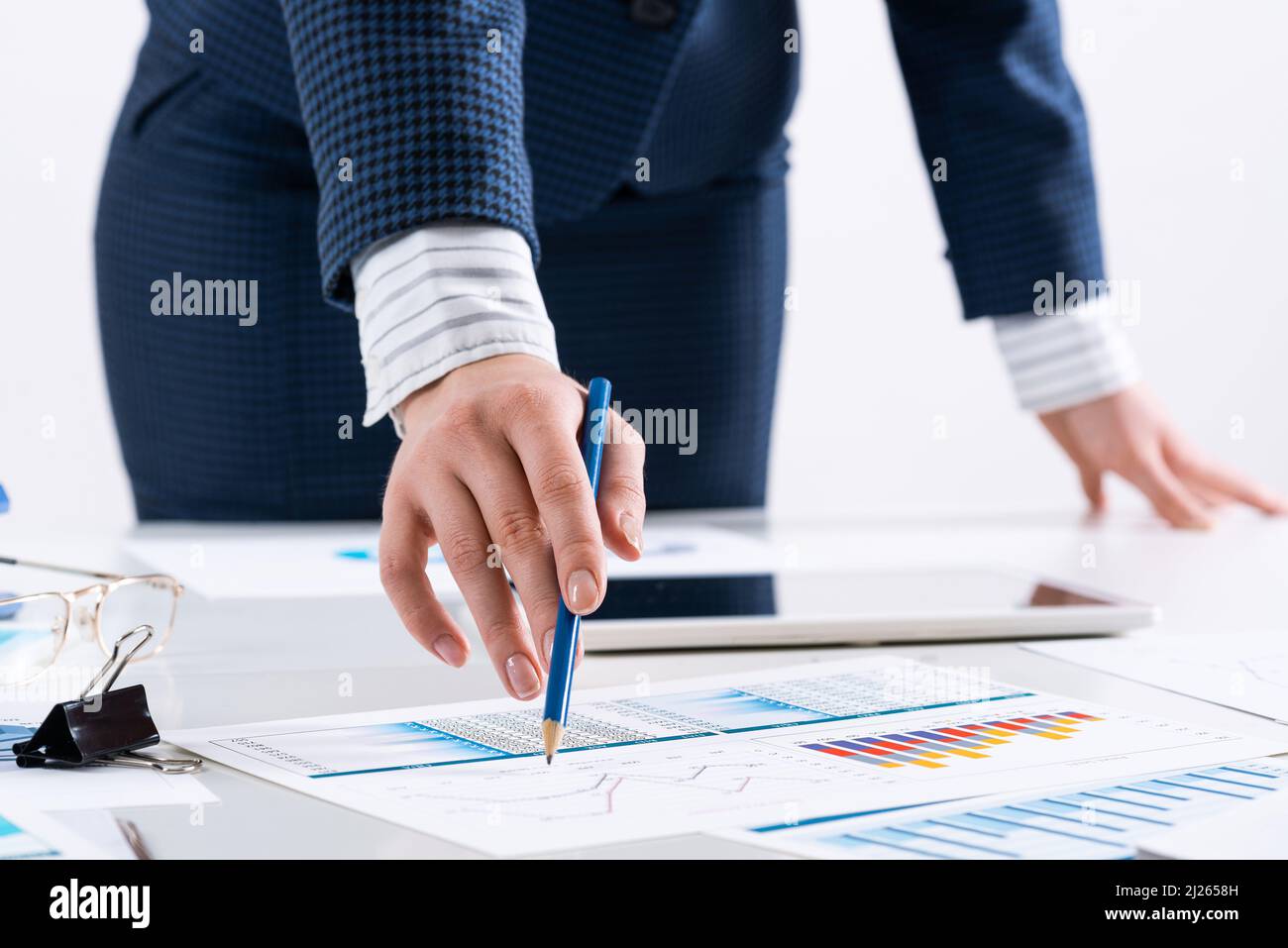 Businesswoman standing near office desk with pen Stock Photo - Alamy