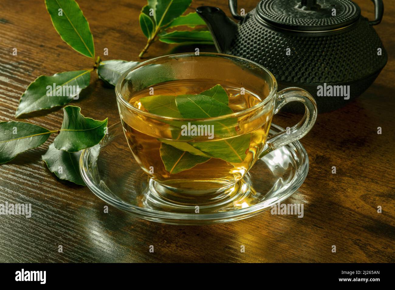 Bay leaf tea. Laurel leaves infusion with a cup and a teapot, on a dark ...
