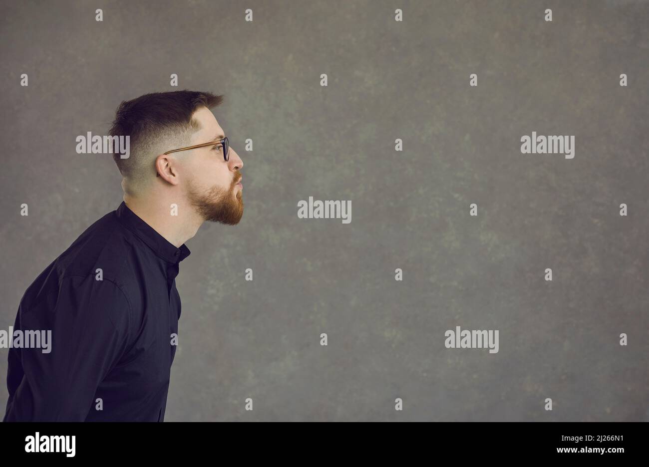 Side view of funny man pouting lips and kissing empty space on copy ...