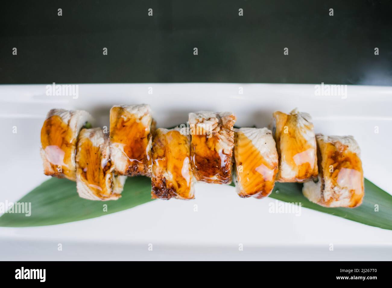 a sushi roll with eel and unagi sauce on a plate japanese cuisine Stock ...