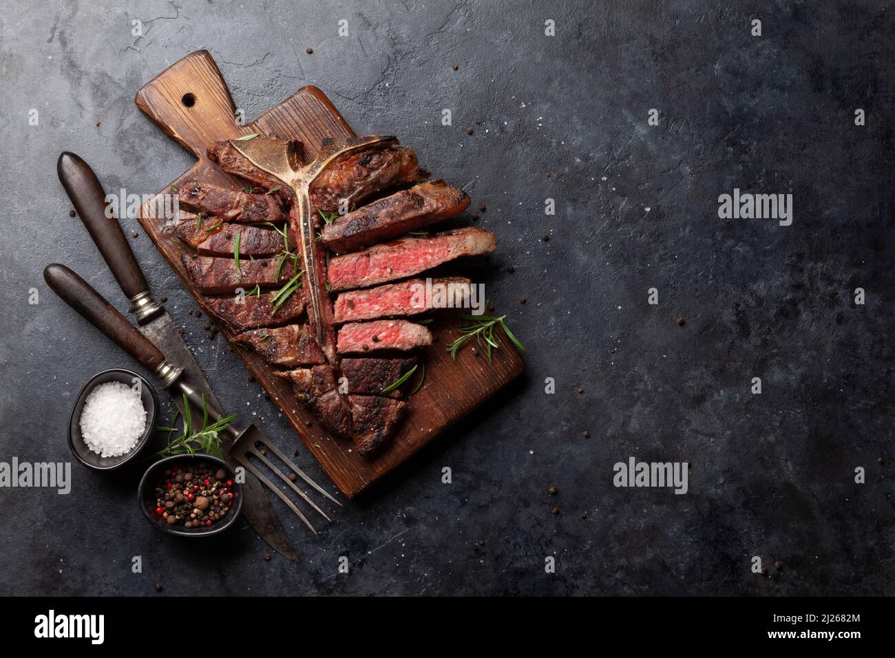 Grilled porterhouse beef steak. Sliced T-bone with herbs and spices ...
