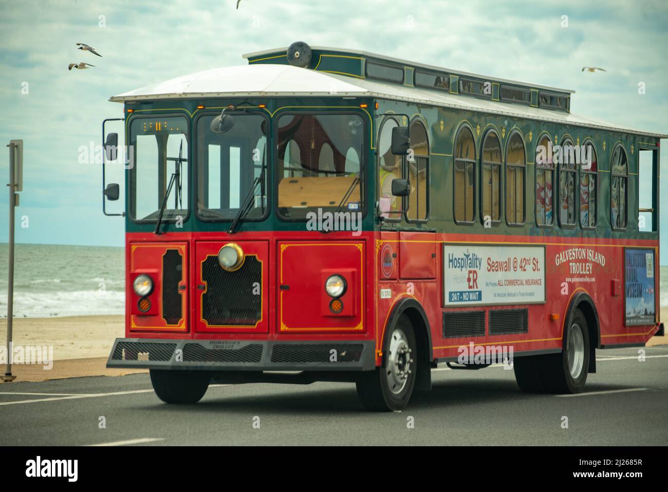 A red public bus with an ocean in the background Stock Photo - Alamy