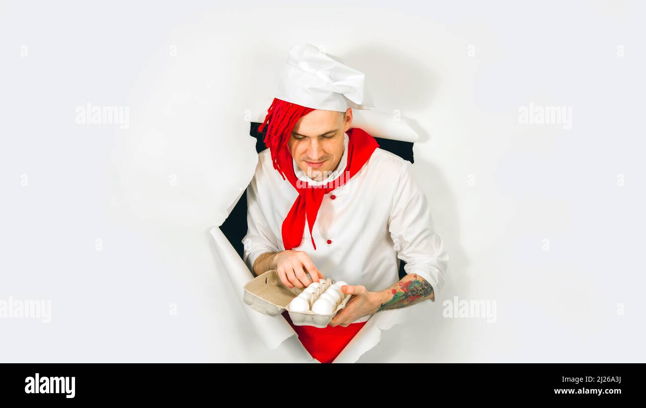 A handsome man with red dreadlocks holds it in his hand chicken eggs ...