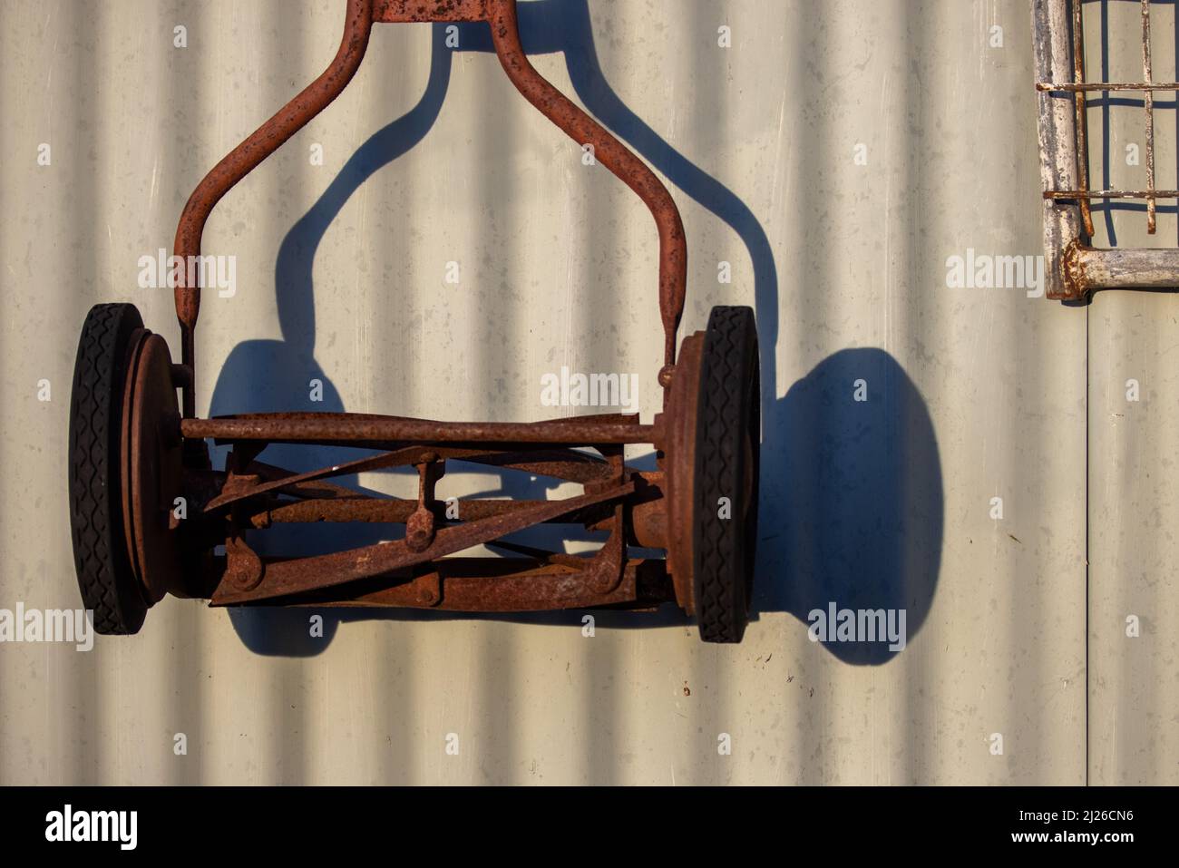 A closeup of an old, rusty reel mower hanging on the wall Stock Photo ...