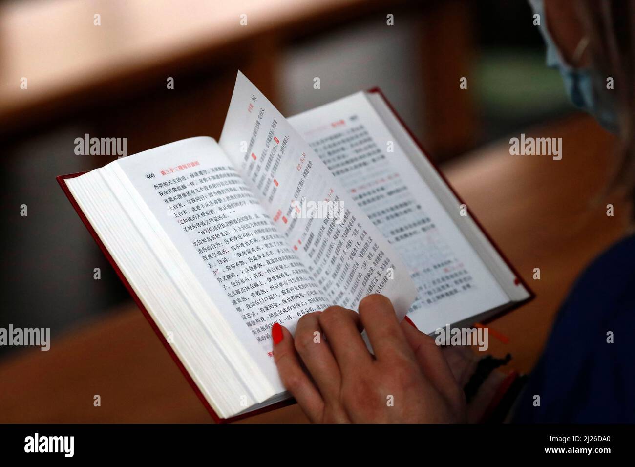 Catholic woman reading a chinese bible Stock Photo - Alamy