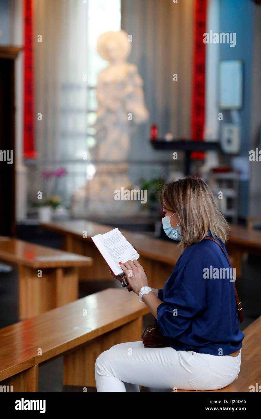 Catholic woman reading a chinese bible Stock Photo - Alamy