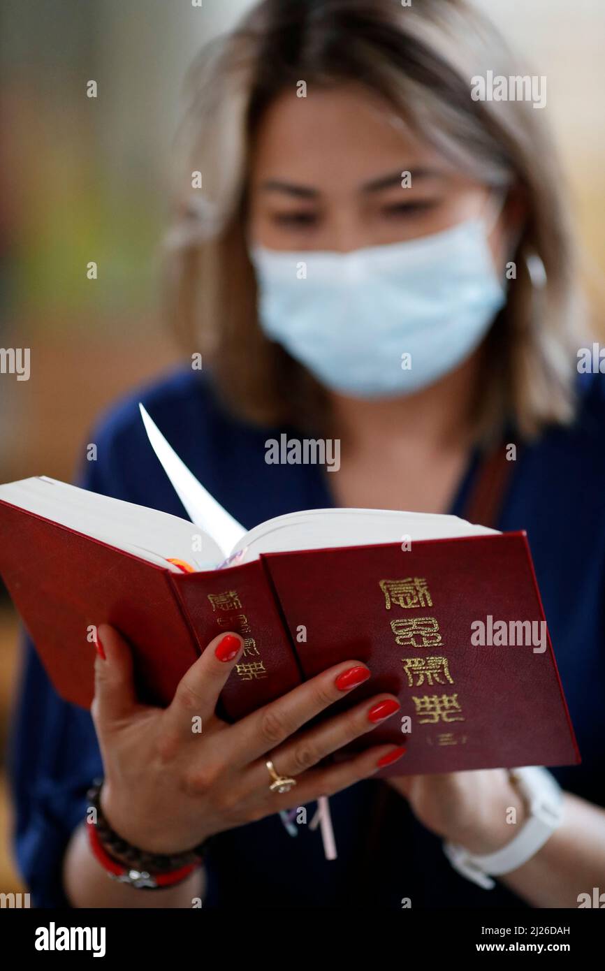 Catholic woman reading a chinese bible Stock Photo - Alamy