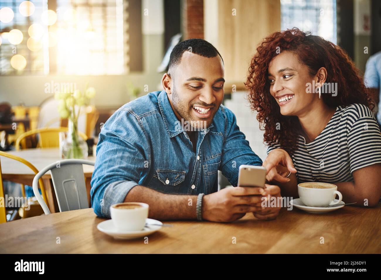 I remember this day.... Cropped shot of an affectionate young couple looking at a cellphone ...