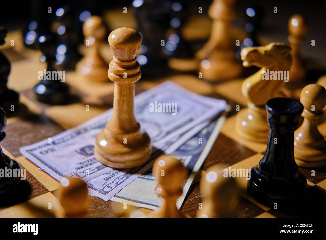 Money in US dollar bills on an old chessboard with retro chess pieces ...