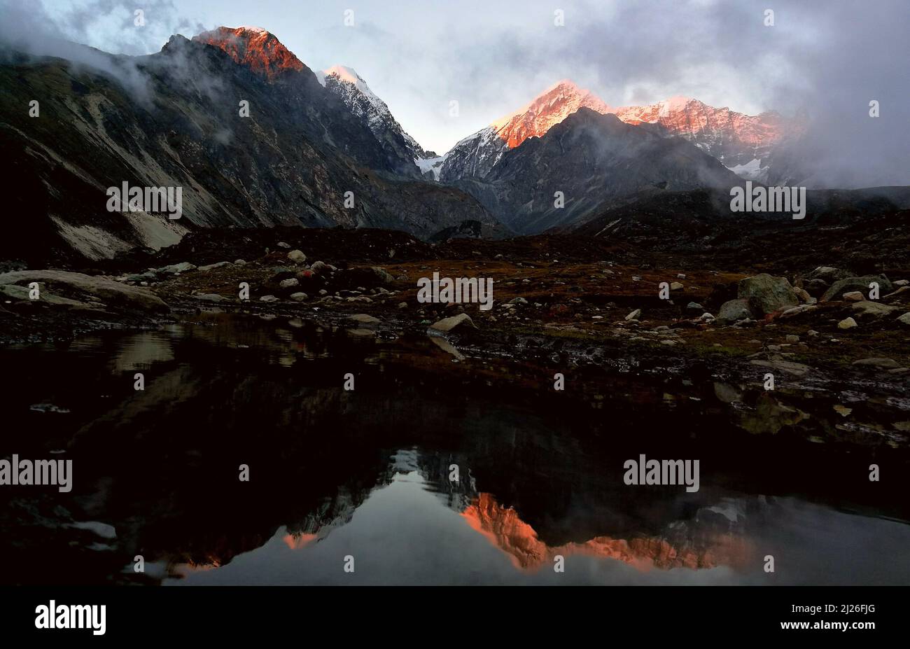 A the lake reflects the low mountains in the distance under a light ...