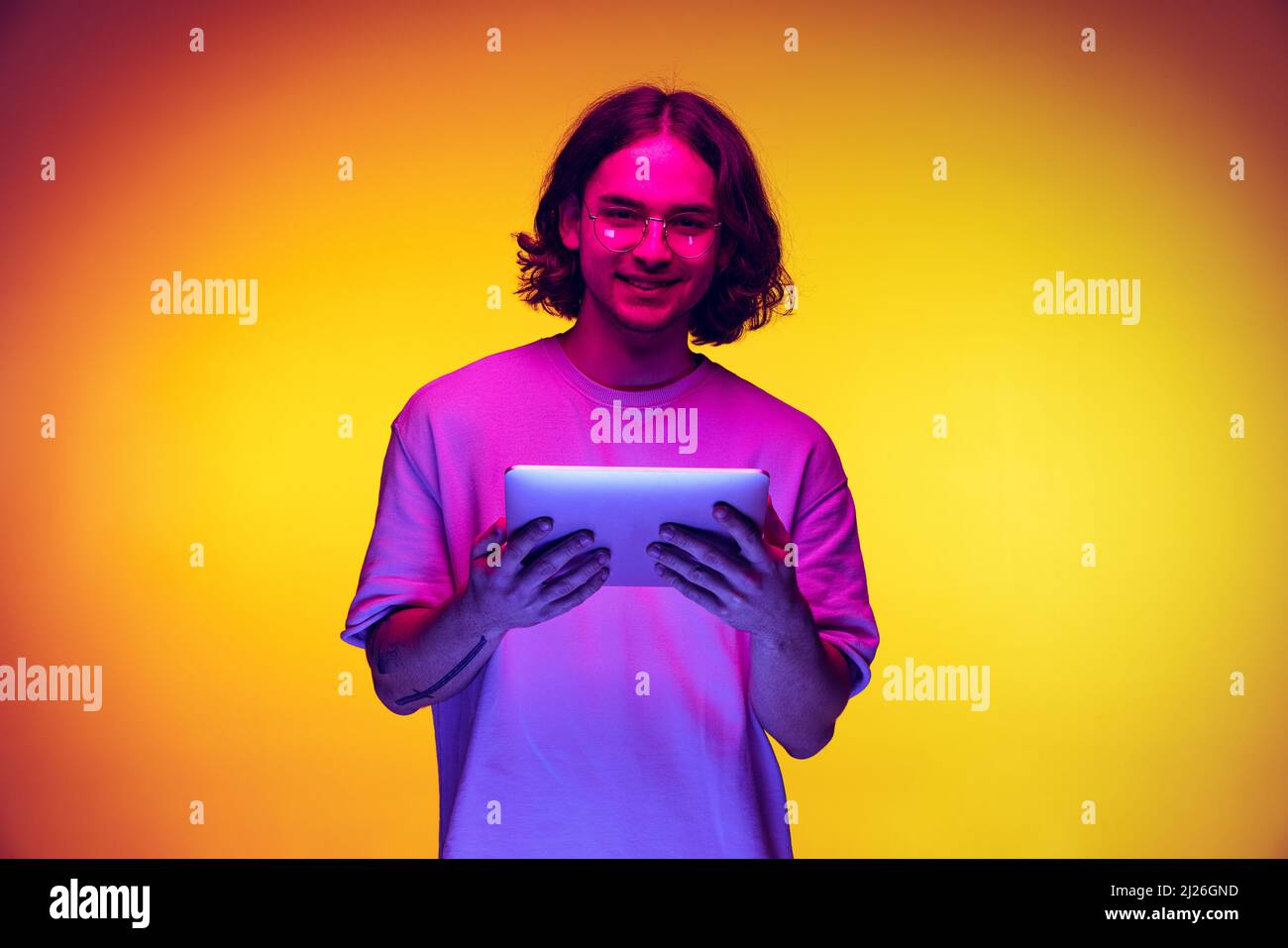 Portrait of young man with long hair using digital gadget isolated on ...