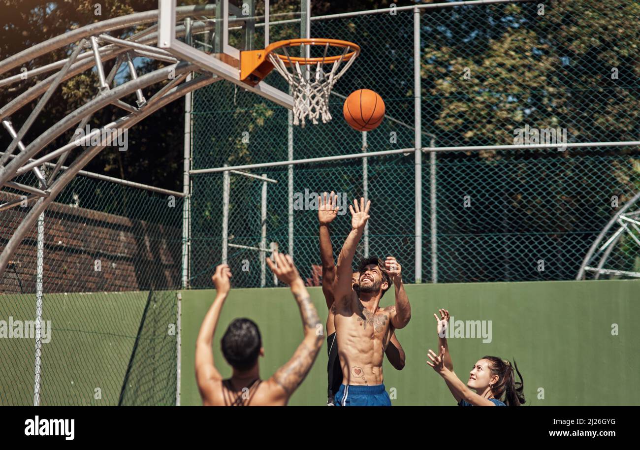 Will he make the shot. Shot of a group of sporty young people playing ...