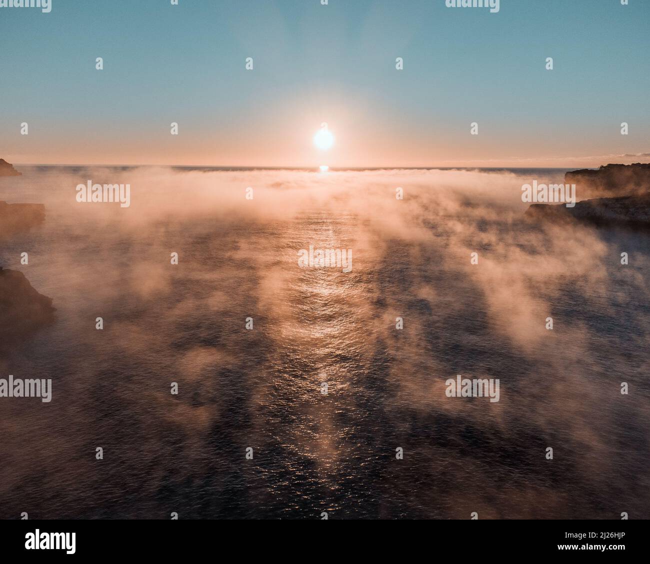 A scenic aerial view of mist over the sea during sunset Stock Photo - Alamy