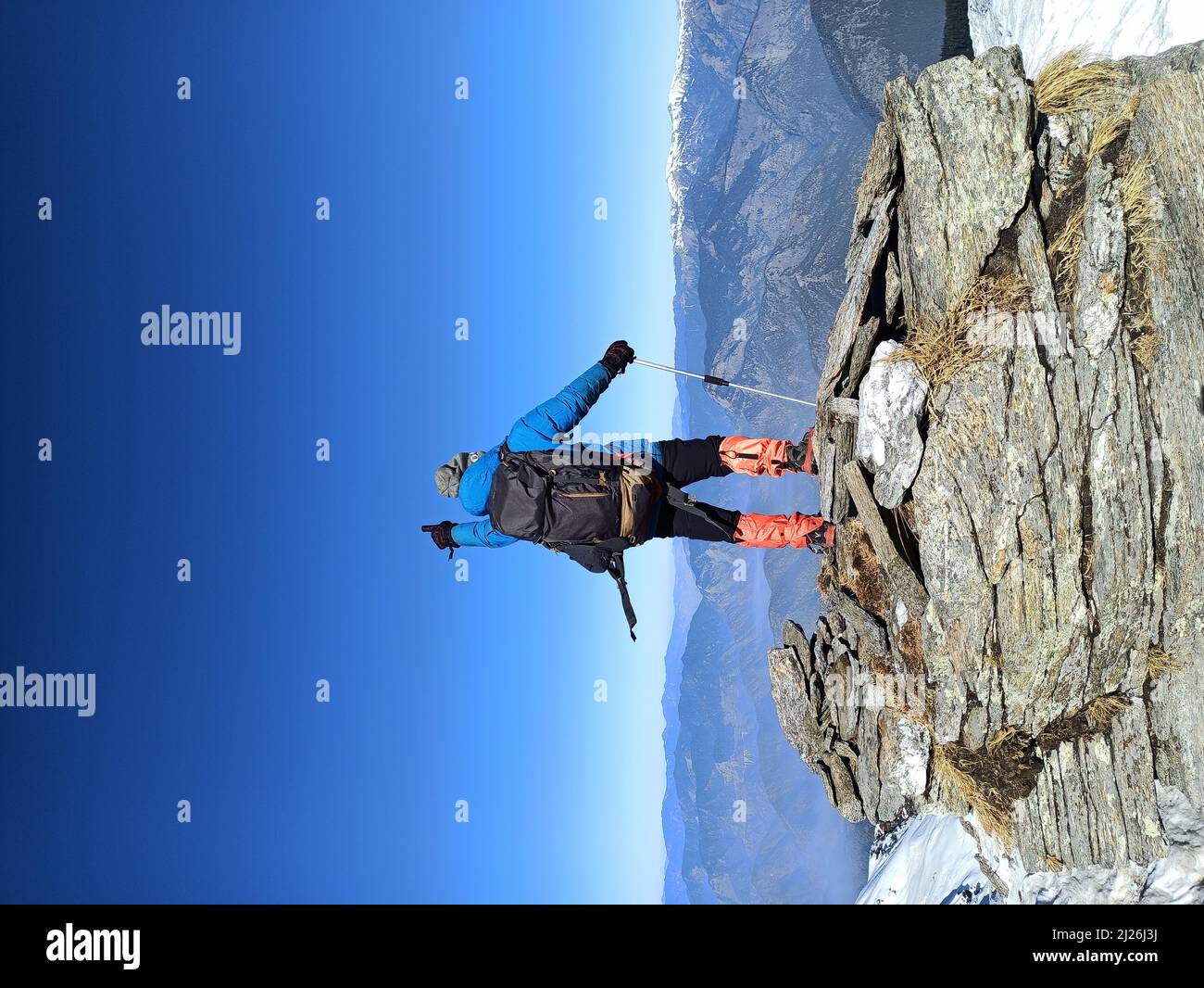 A vertical shot of a person in hiking gear on a mountain Stock Photo ...