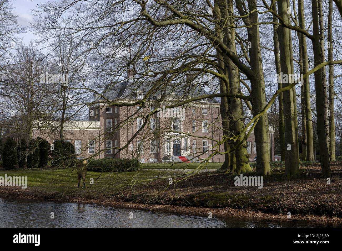 Slot Zeist castle seen through winter barren trees on a sunny day with ...