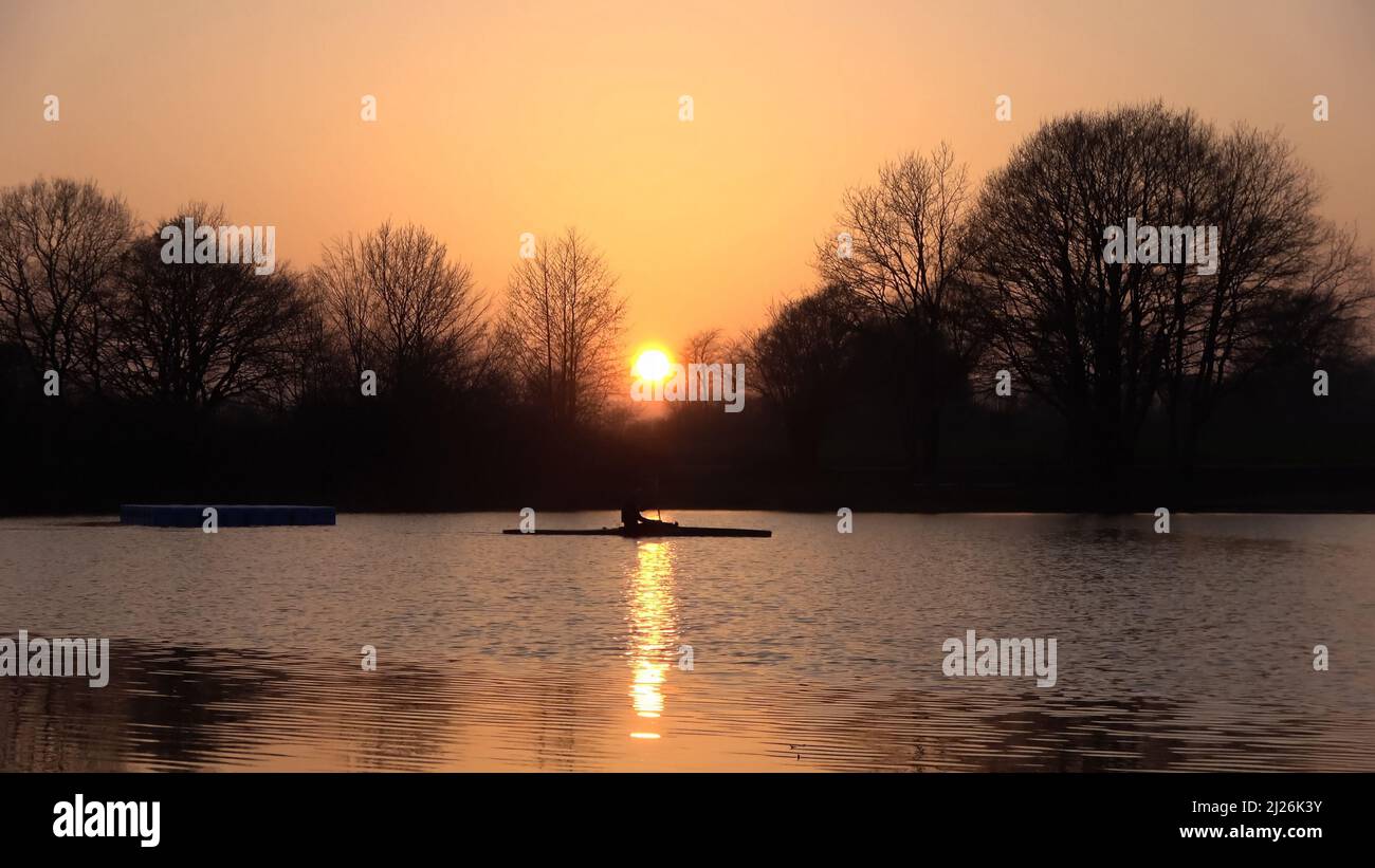 A rower on a lake in a dream sunset Stock Photo - Alamy