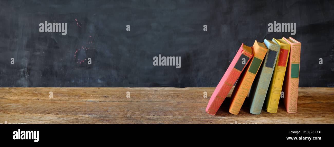 Row of books on dark background, panoramic with large copy space ...
