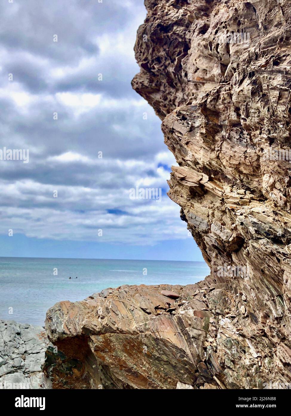 close up of the edge of a jagged coastal cliff face with rough rugged ...