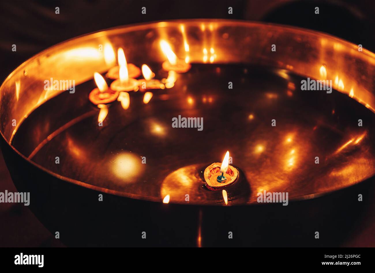 Candle in walnut shell placed in a bowl of water. Christmas tradition ...