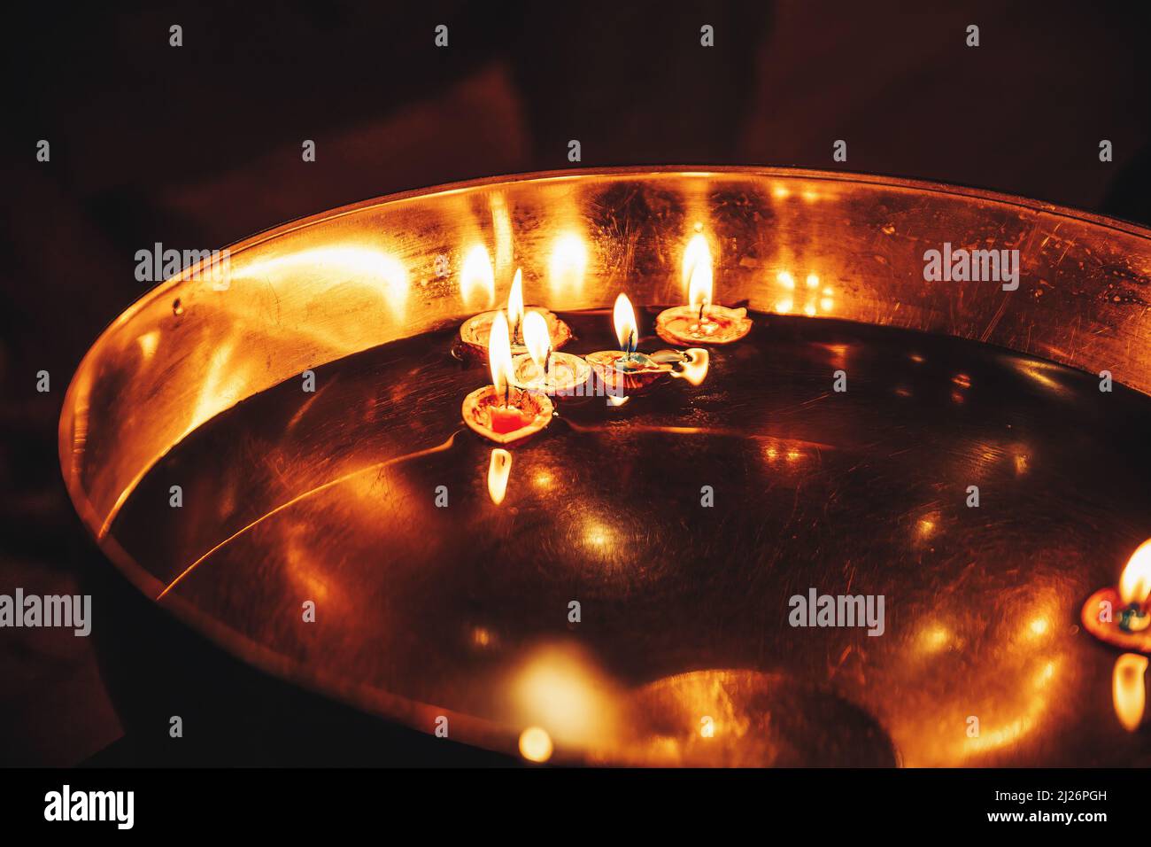 Candle in walnut shell placed in a bowl of water. Christmas tradition ...