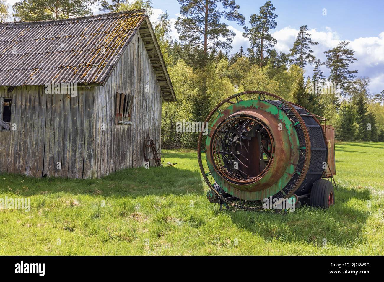 Old potato picker machine by a wooden barn in the countryside Stock ...