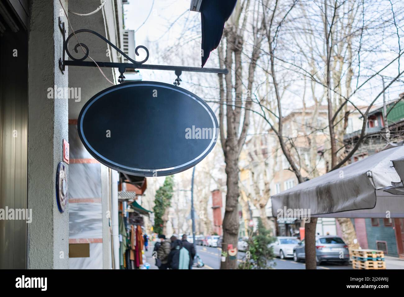 Black metal hanging sign on the facade of a building at the entrance of ...